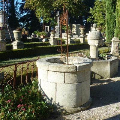 Beautiful stone well in a rustic style, made of natural carved stone.